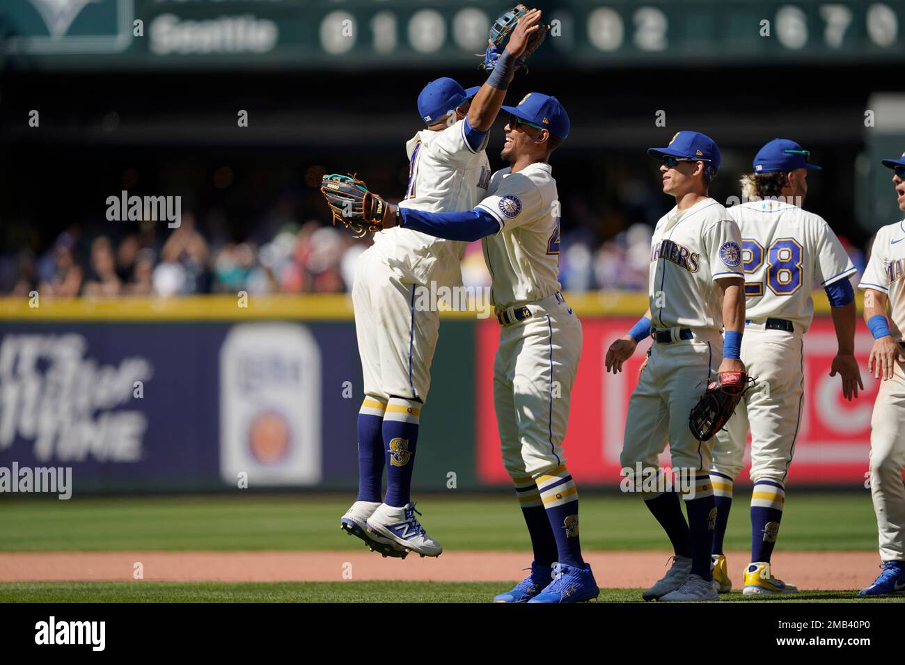 Seattle Mariners' Carlos Santana, left, is hugged by Julio Rodriguez ...