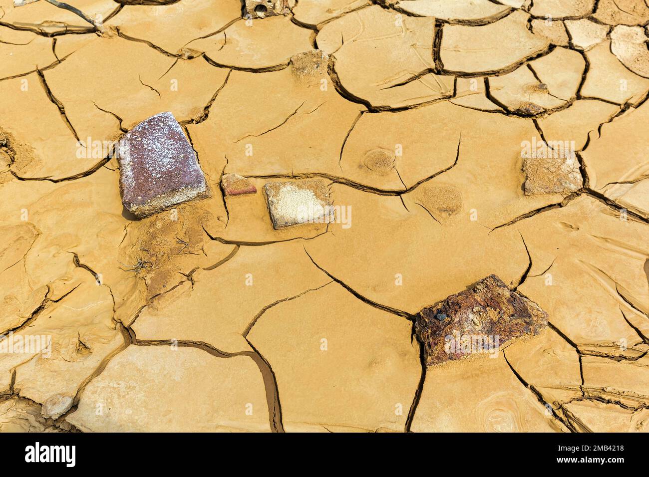 Parched soil and stones, dry cracks after flooding, drought, climate ...
