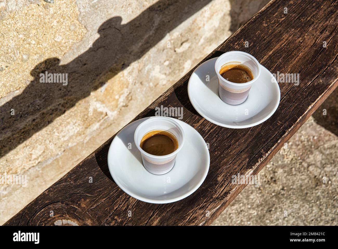 Espresso, Italian coffee speciality in two plastic cups, on a bench ...