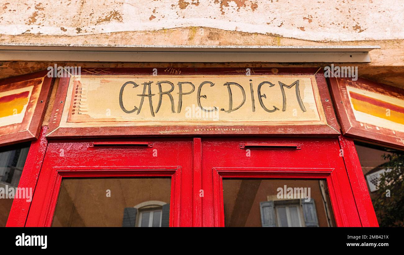 Lettering Carpe Diem, Seize the Day, motto above a red entrance door ...