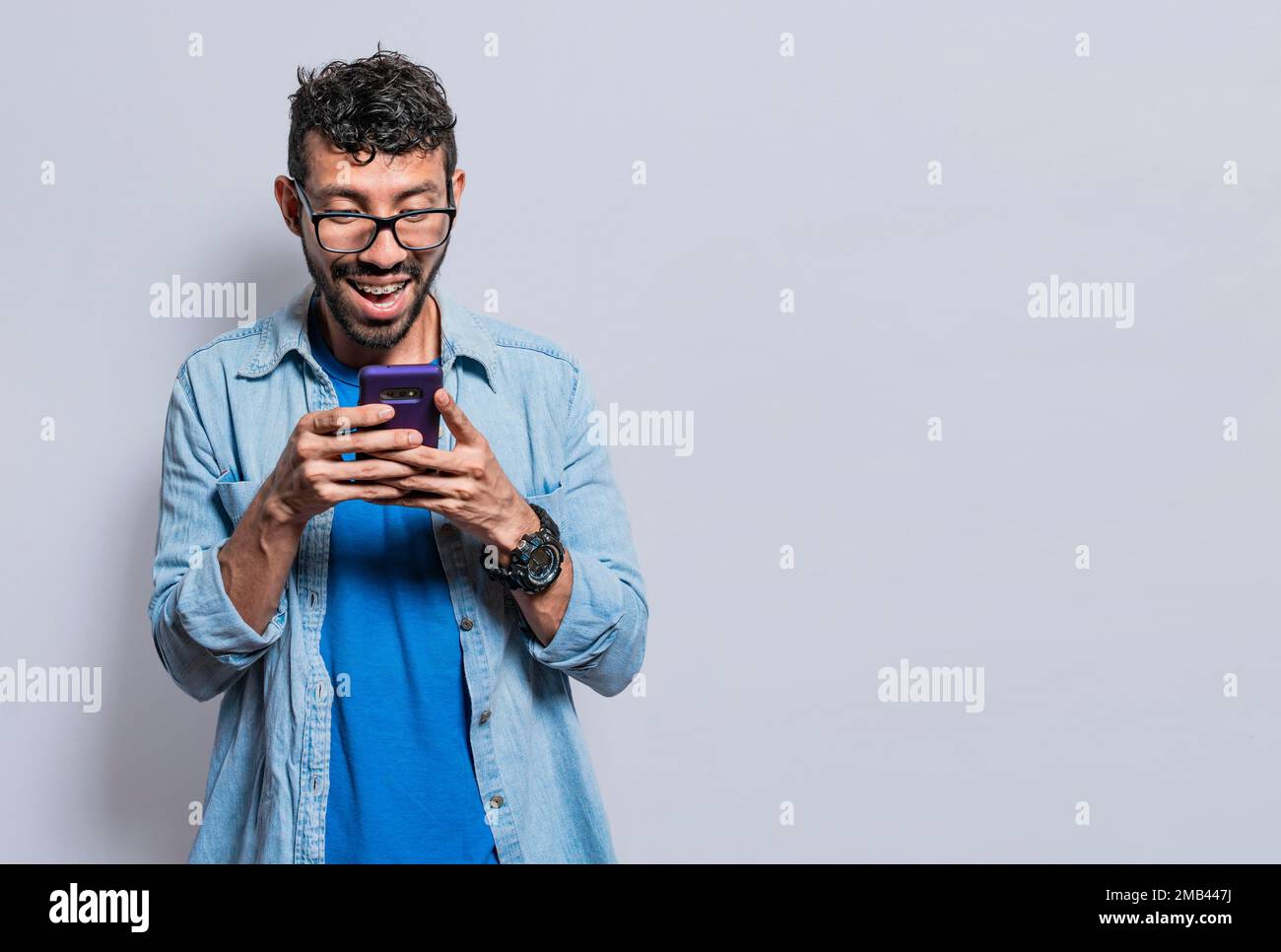 Smiling handsome boy texting with his cell phone isolated, young latin ...