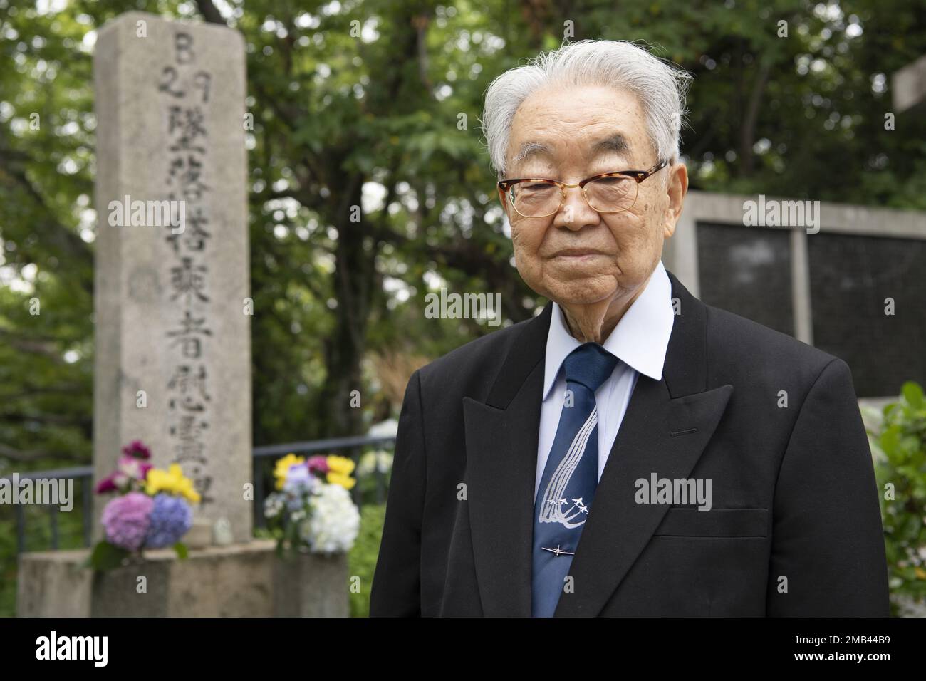 Dr. Hiroya Sugano, ceremony host, stands in front of a B-29 Monument ...