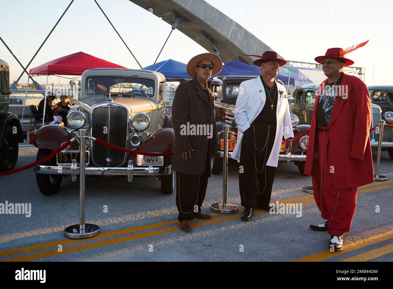 Pachucos wear Zoot suits as they pose with vintage cars lined up for ...