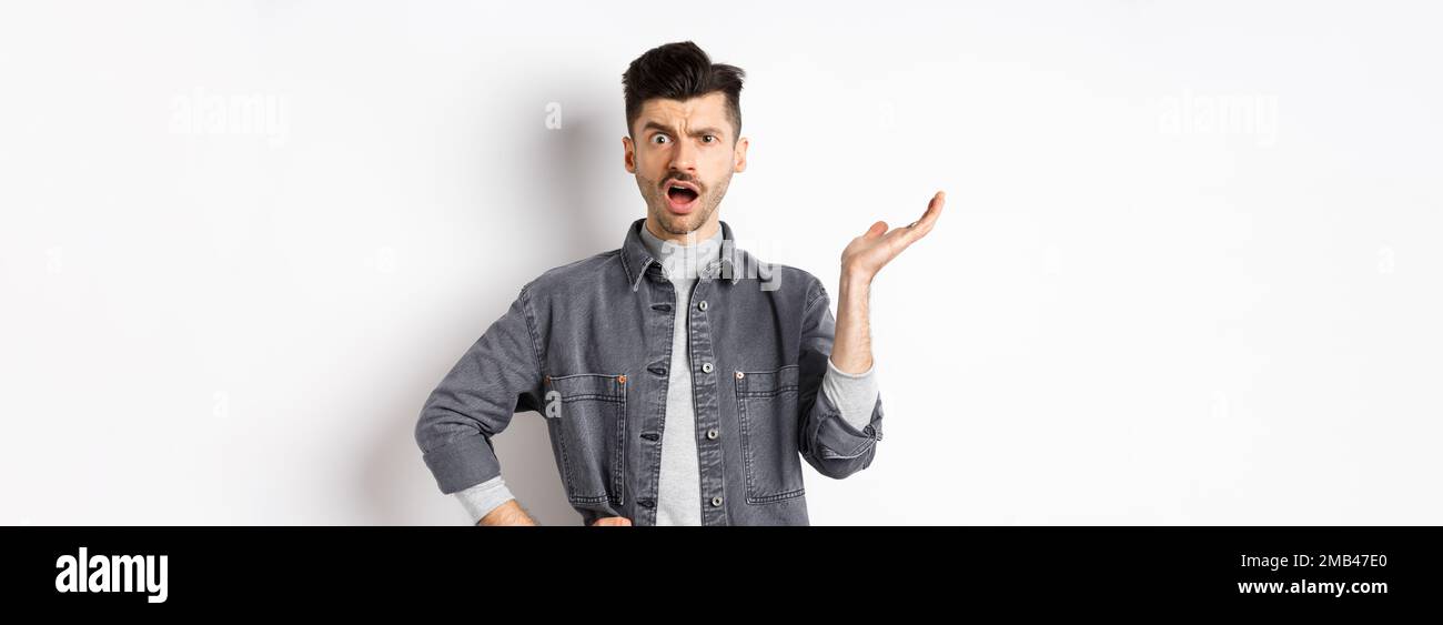 Confused and annoyed guy raising hand up and complaining, asking wtf ...