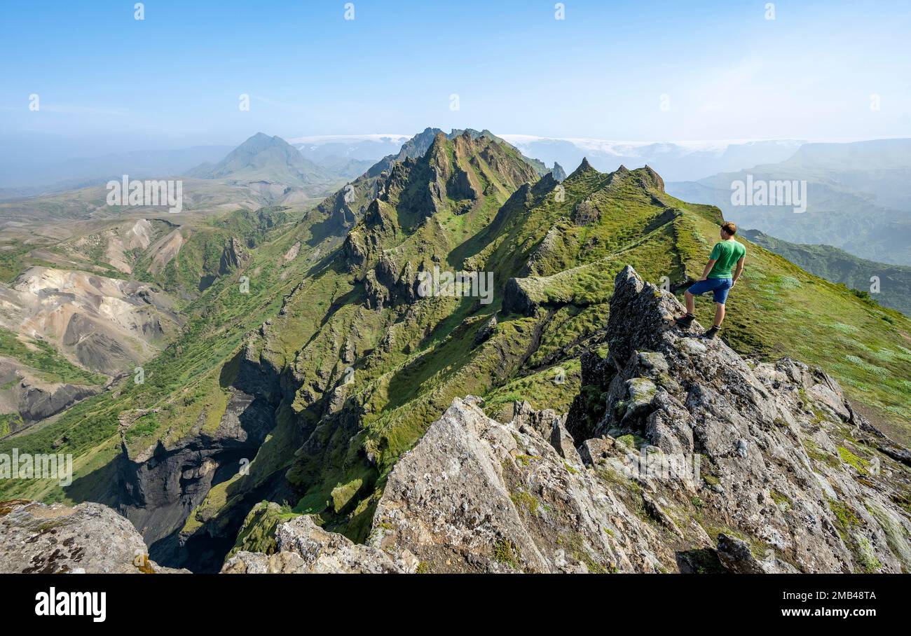 Hikers on rocks, Pointed green mountain peaks on the ridge of ...