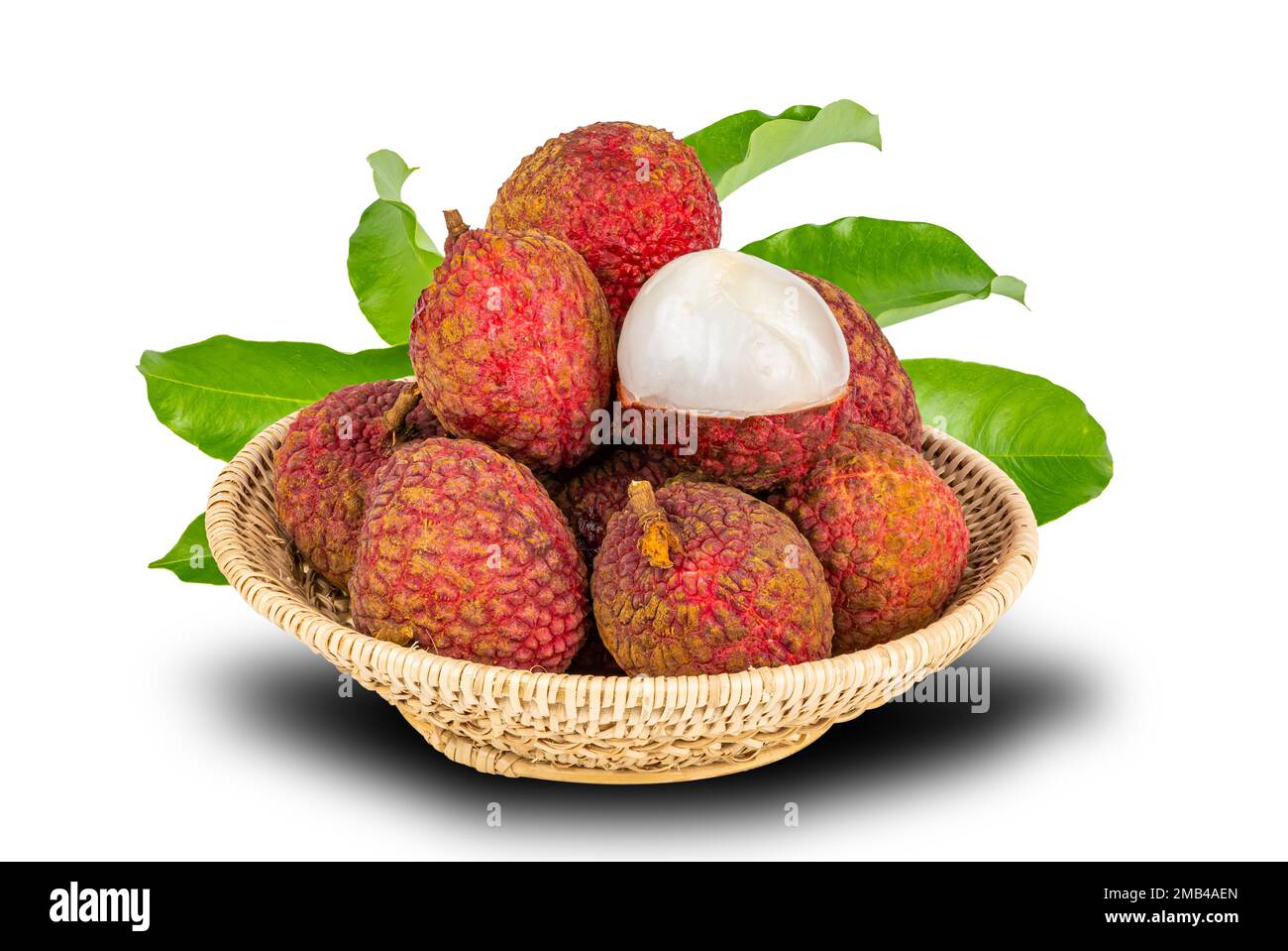 Pile of ripe lychee with green leaves in bamboo basket isolated on ...