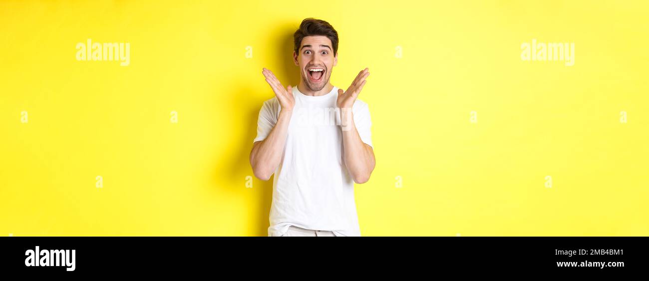 Surprised and happy man reacting to announcement, smiling and looking ...