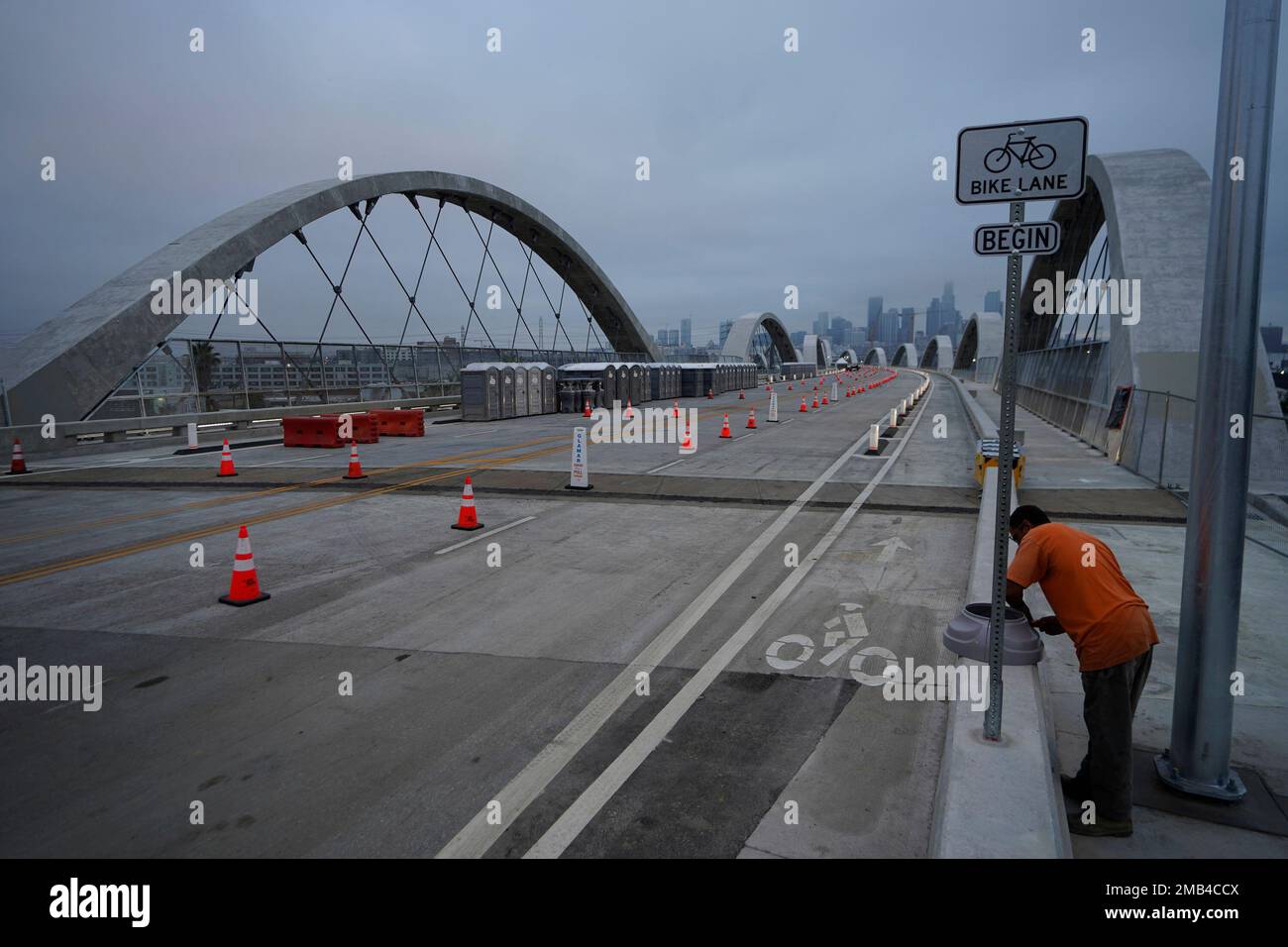 A worker fixes the base of a lamp post cover at the Sixth Street ...