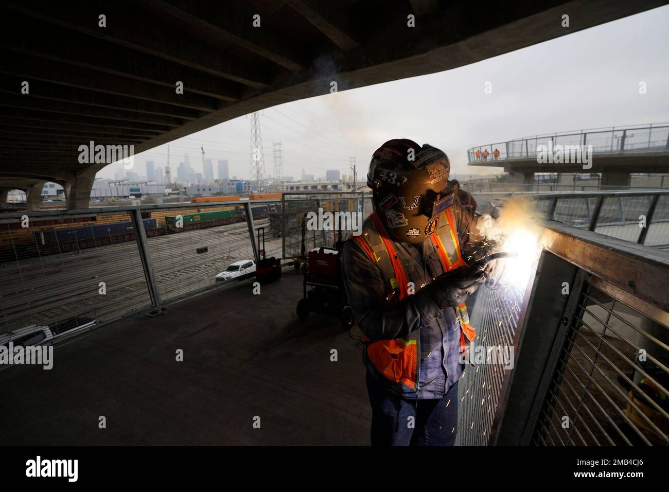 Iron worker Luis Galan, with Local 433, welds a metal rail under the ...