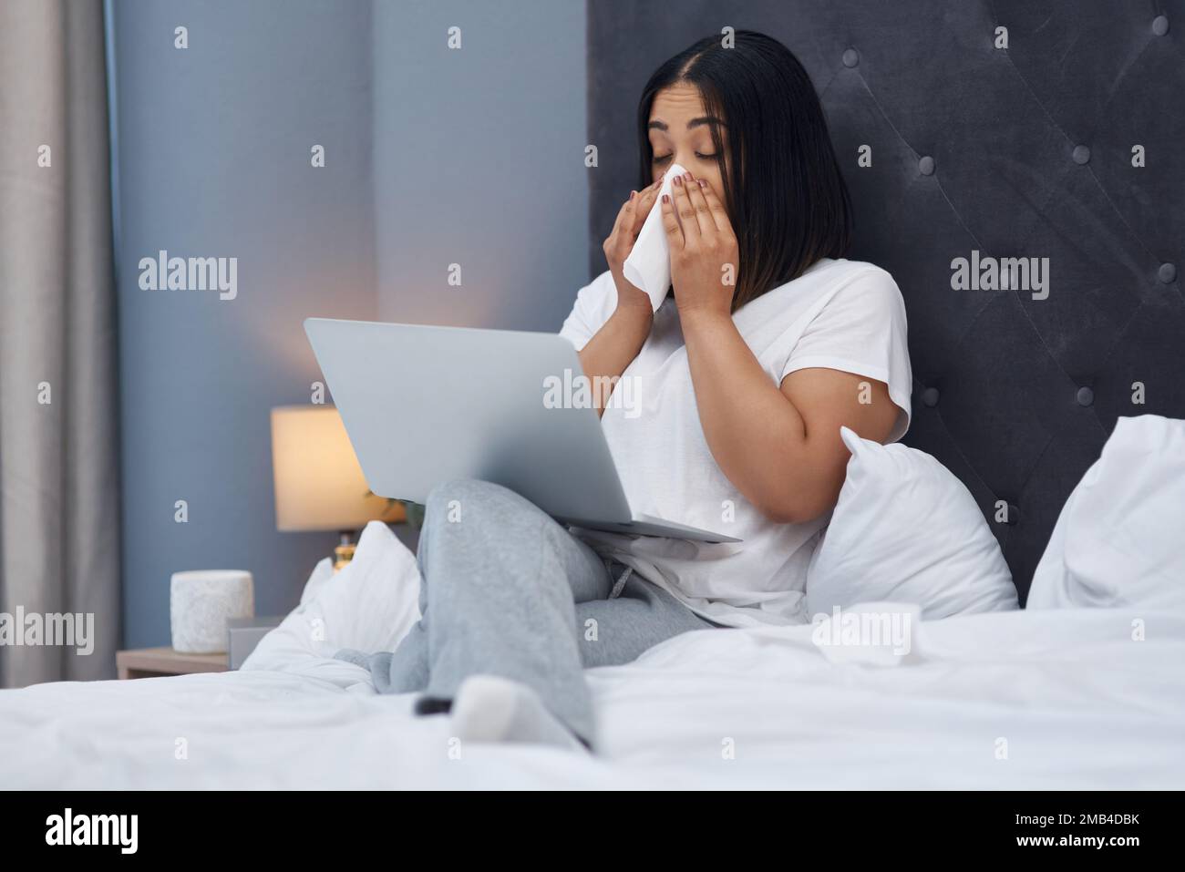 Flu season kicking in. a young woman feeling sick in bed at home Stock ...