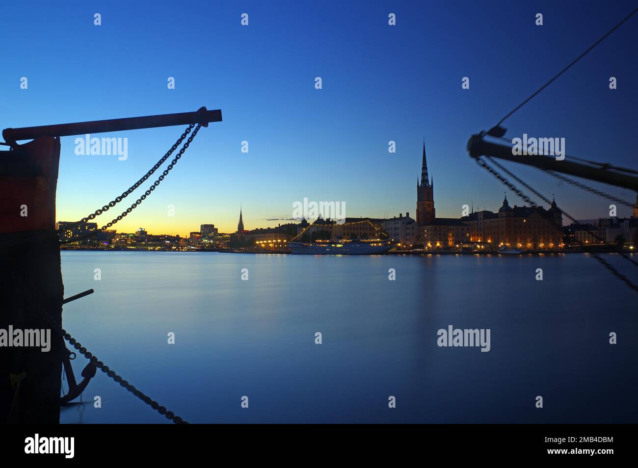 Illuminated harbour front at blue hour, Gamla Stan, passenger ship ...