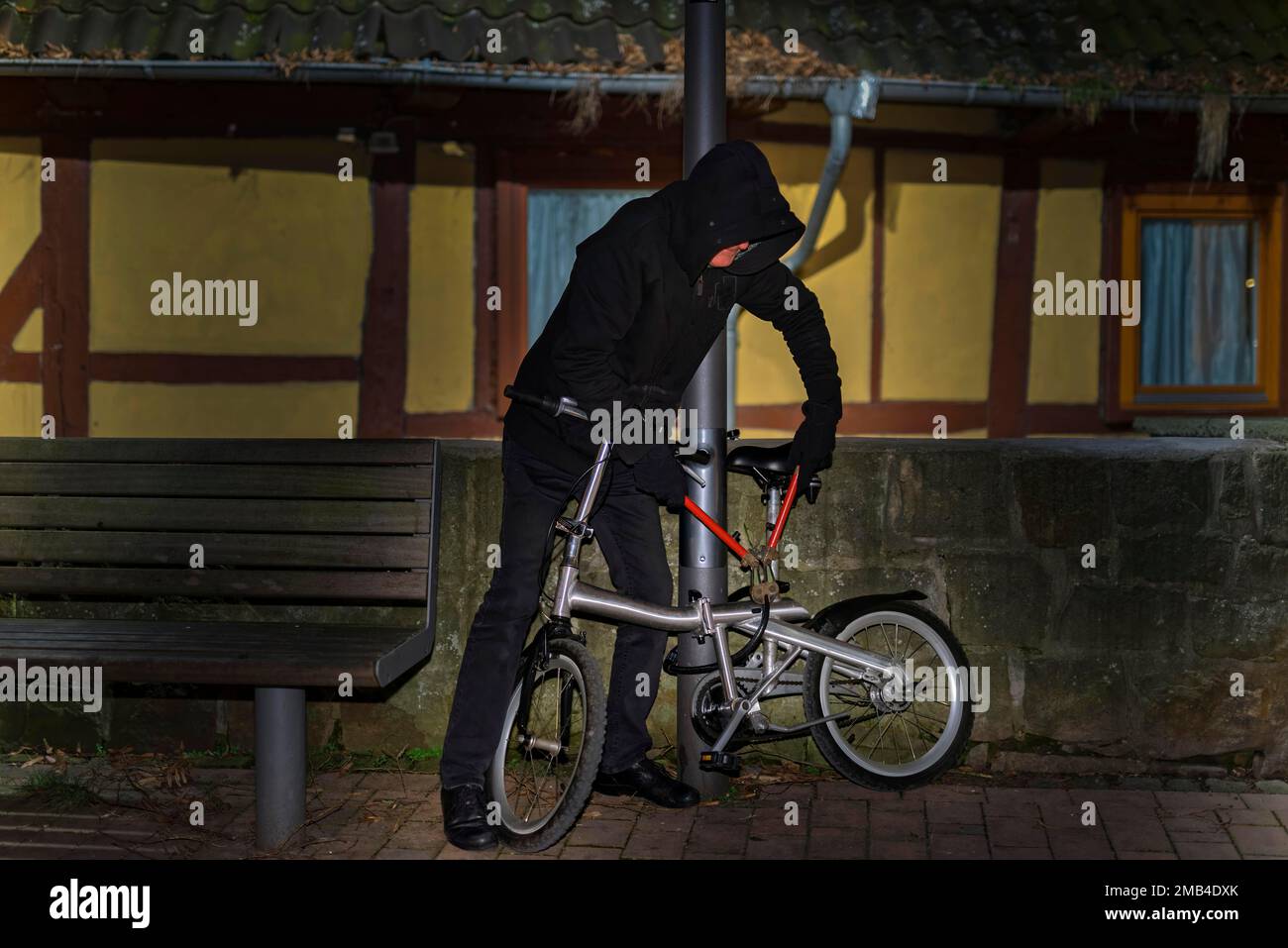 Bicycle theft night, man steals bicycle, symbolic image Stock Photo - Alamy
