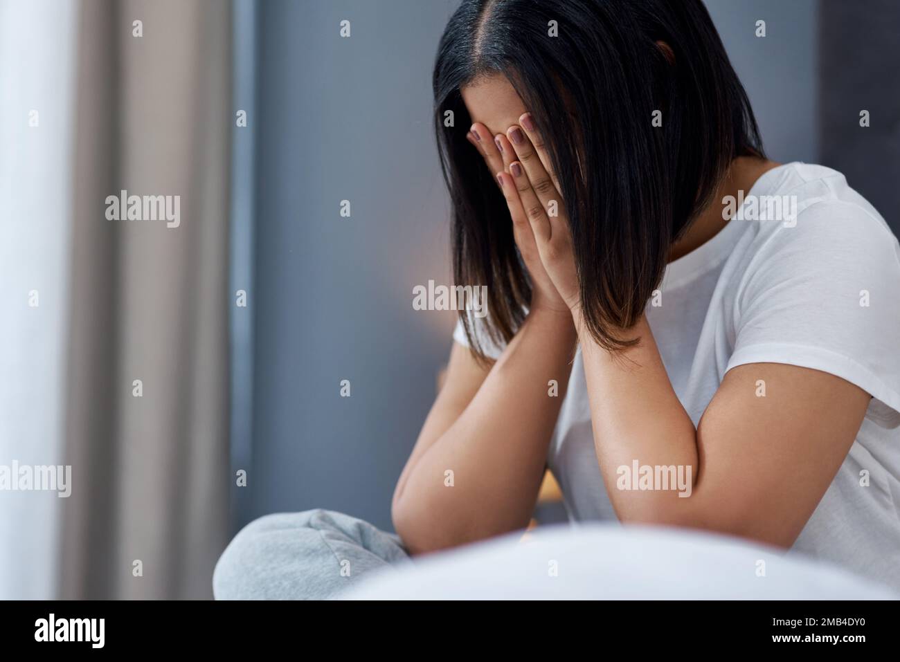 Not ready to face this day. a young woman feeling unhappy in bed at ...