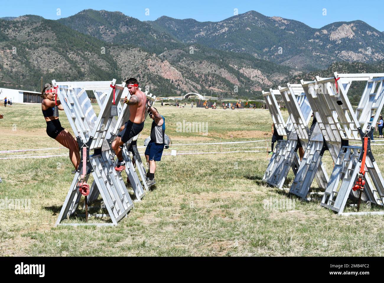 FORT CARSON, Colo. — Athletes move across an obstacle in the Spartan ...
