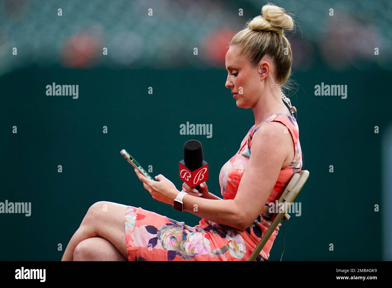 Broadcast reporter Erica Weston looks at a cell phone before giving a ...