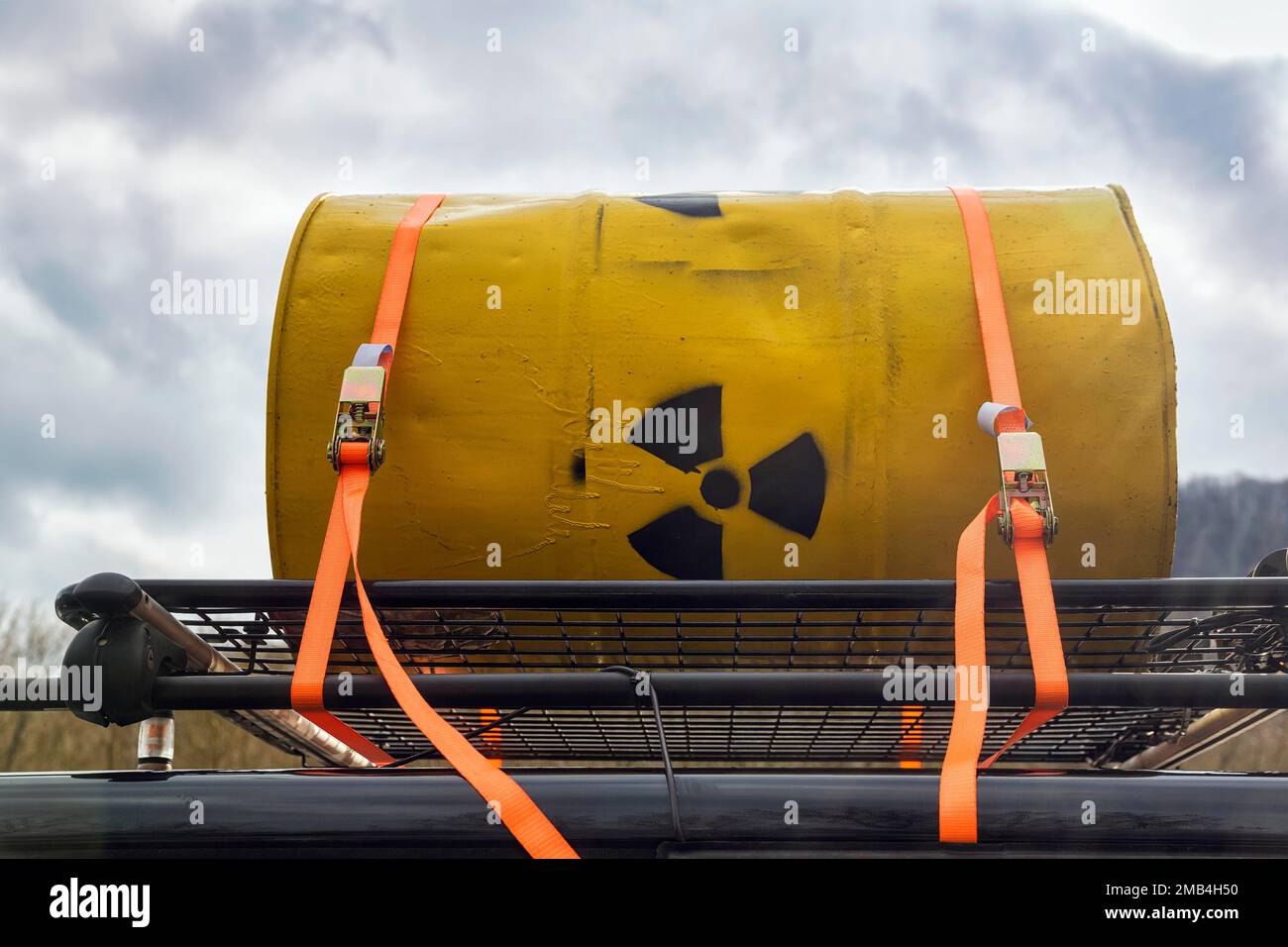Yellow metal barrel with sign for radioactivity on roof rack, fastened ...