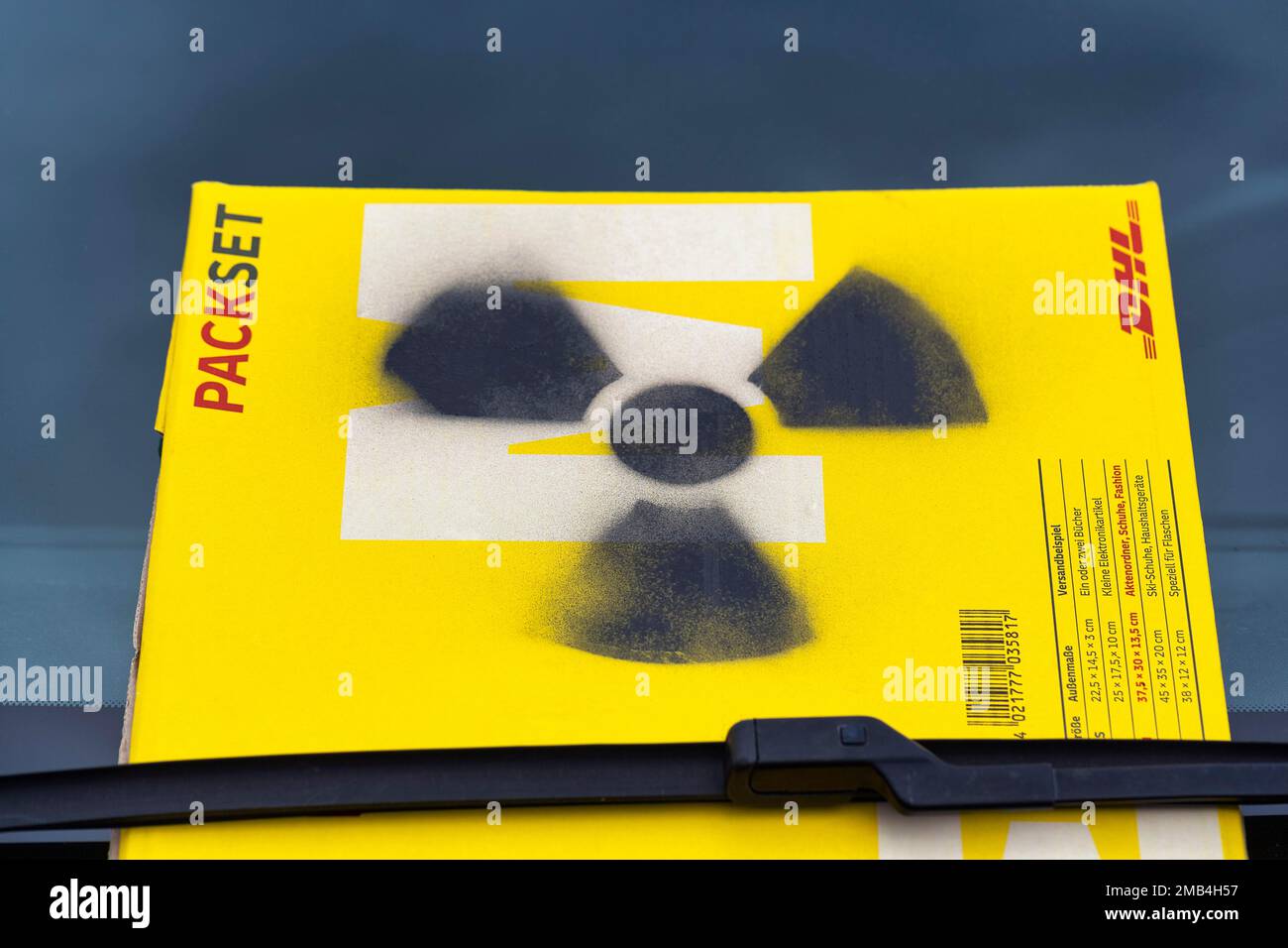 Sign for radioactivity on yellow package, DHL Packset on windscreen ...