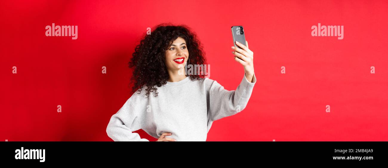 Image of stylish female blogger taking selfie on smartphone, posing for ...