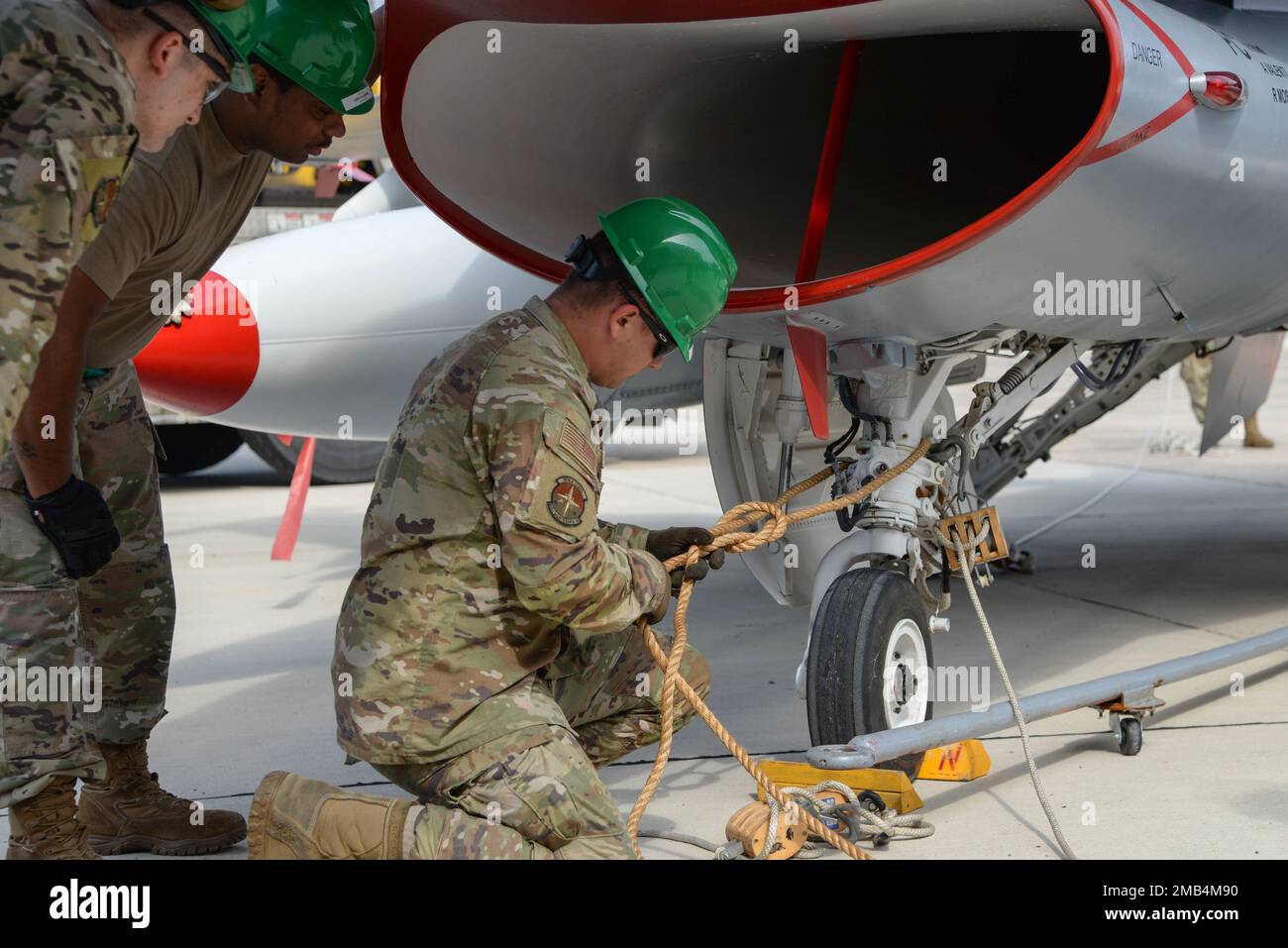 An Airmen secures a decommissioned F-16D fighter jet at a Crash Damage ...