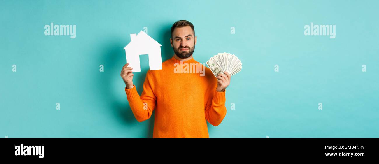 Real estate concept and mortgage concept. Sad man showing house maket ...