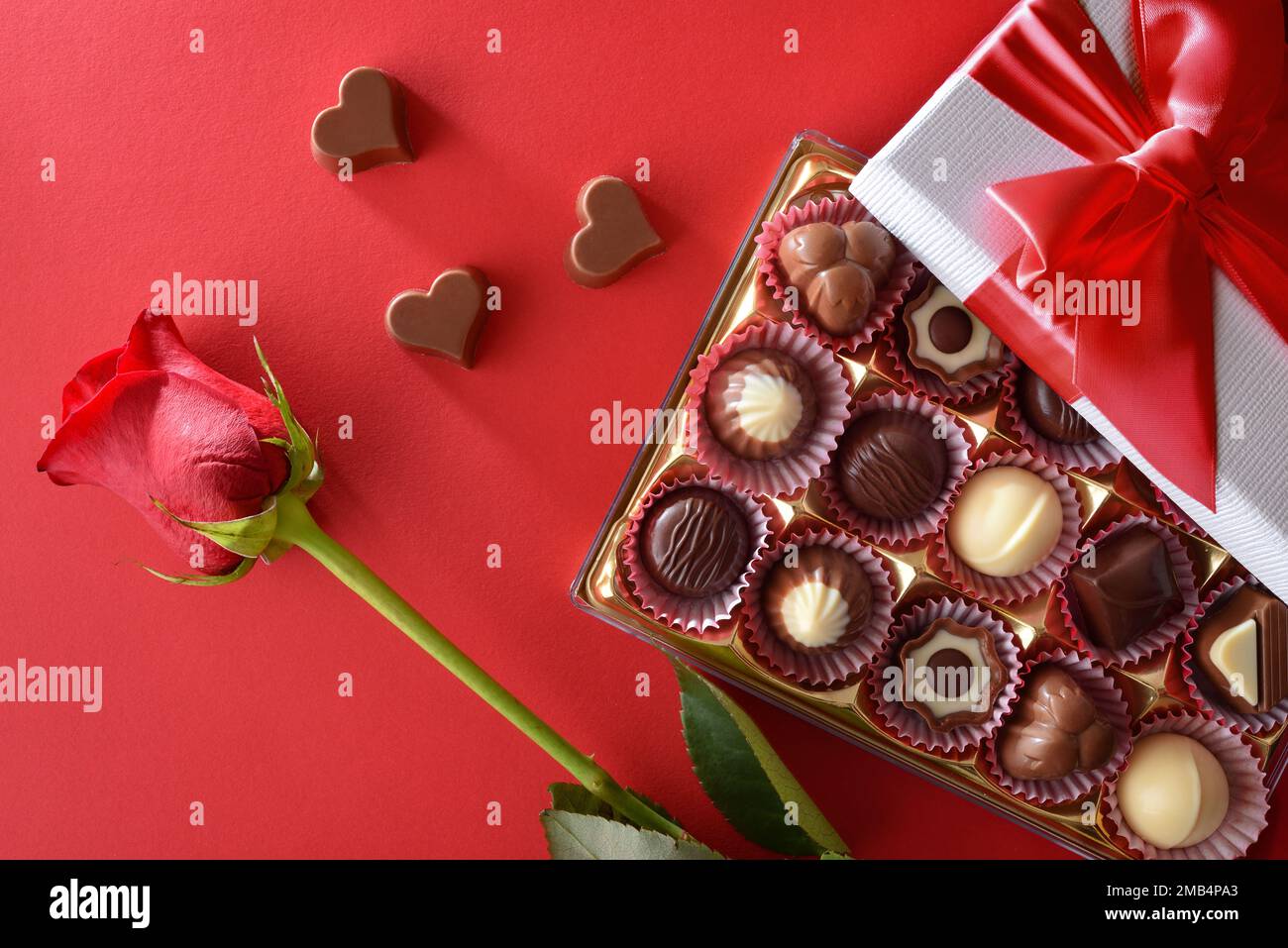 Romantic gift of a box of chocolates with a red rose on a red ...
