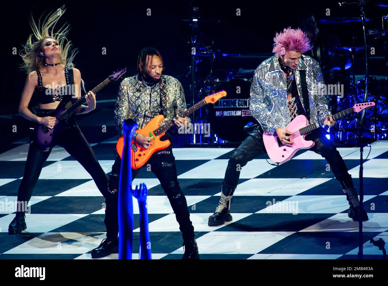 From left, guitarists Sophie Lloyd and Justin Lyons and singer Machine Gun Kelly perform at ...