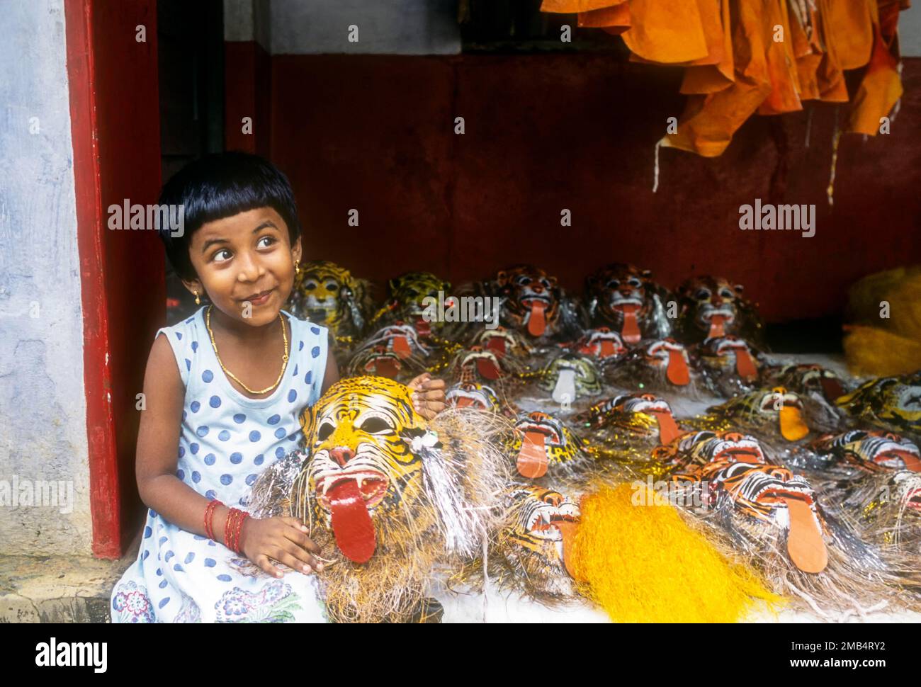 A girl child posing with pulikali mask in her hand in Thrissur or ...