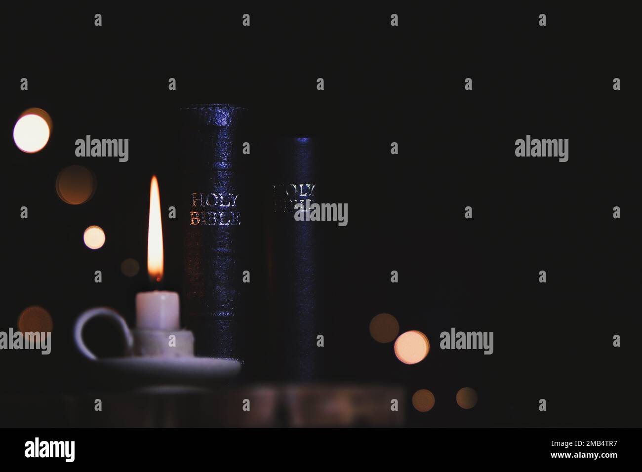 Candlestick and candle and holy cross and bible and light background ...