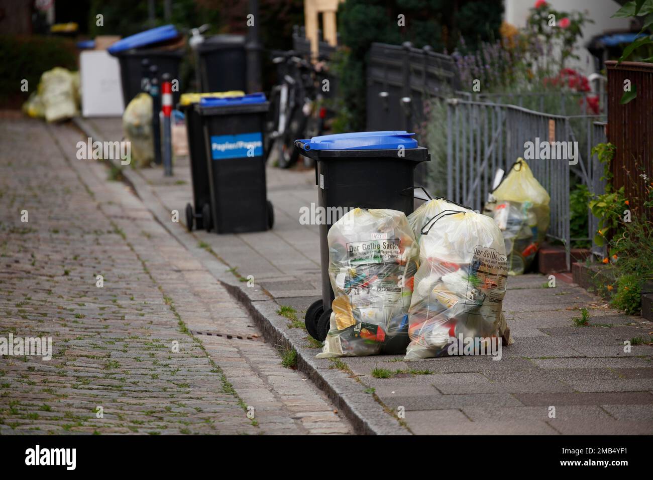 Blue bins for waste paper and yellow bags for plastic waste standing on ...