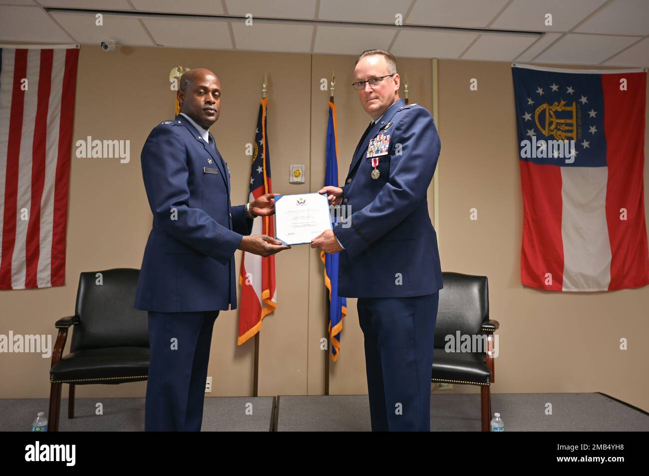 U.S. Air Force Col. Sheldon Wilson presents a retirement certificate to ...