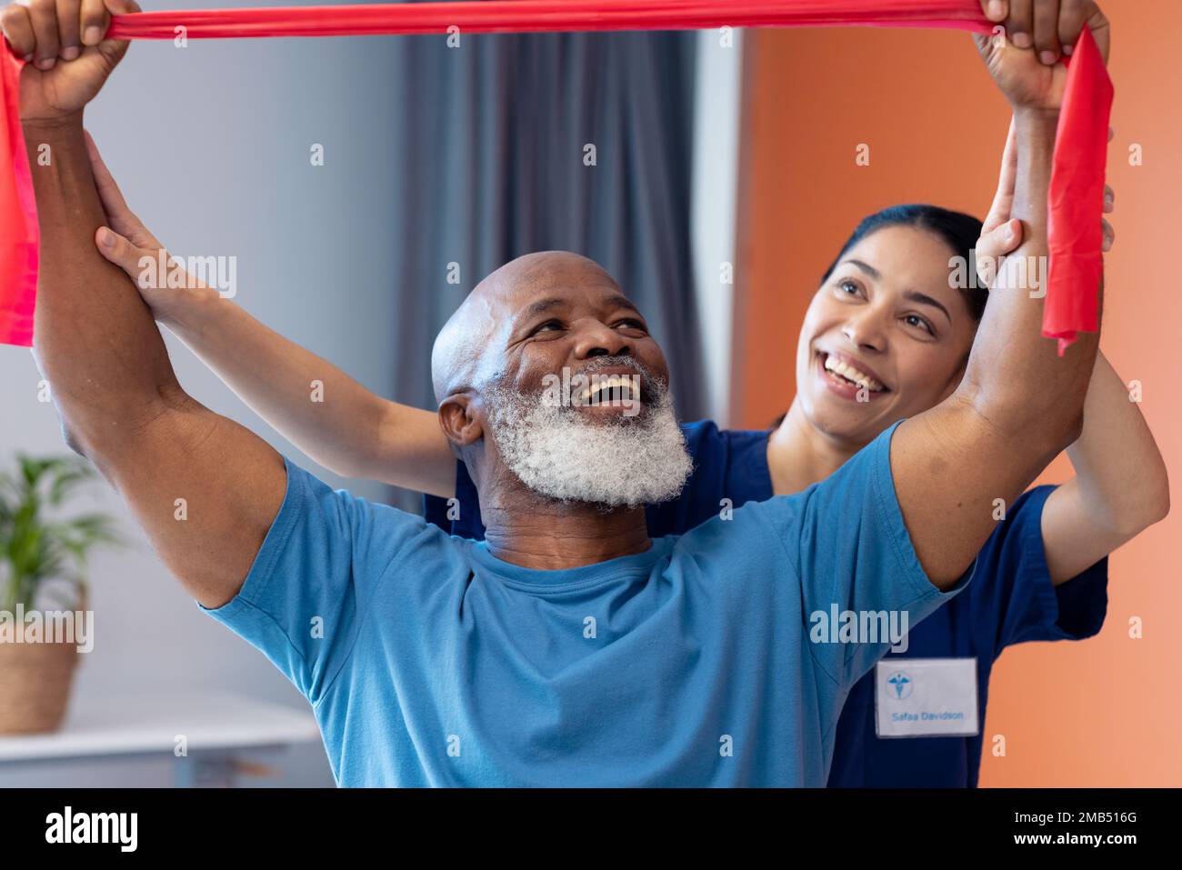 Smiling diverse female physiotherapist and senior male patient ...