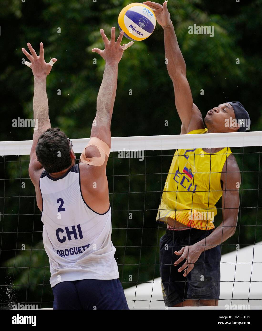Ecuador's Dany Leon, right, spikes the ball to Chile's Vicente Droguett ...