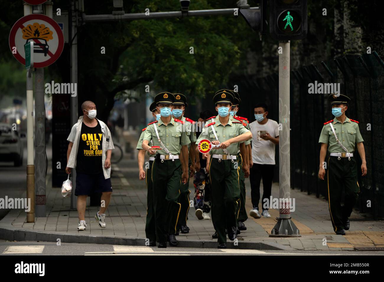 Chinese paramilitary police wearing face masks walk across an ...
