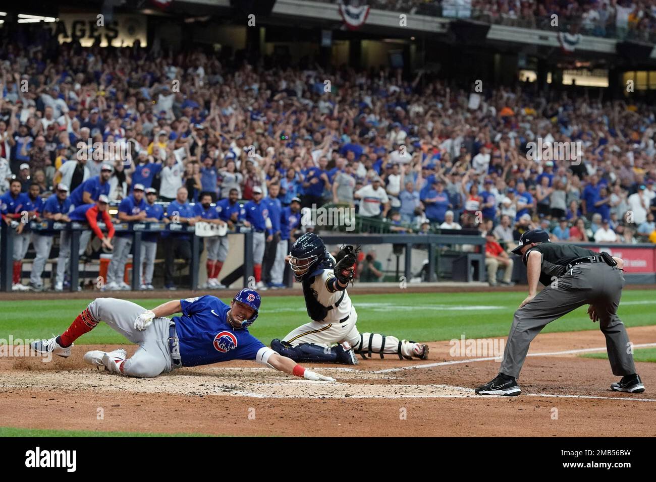 Chicago Cubs' Seiya Suzuki slides safely home after hitting an inside ...