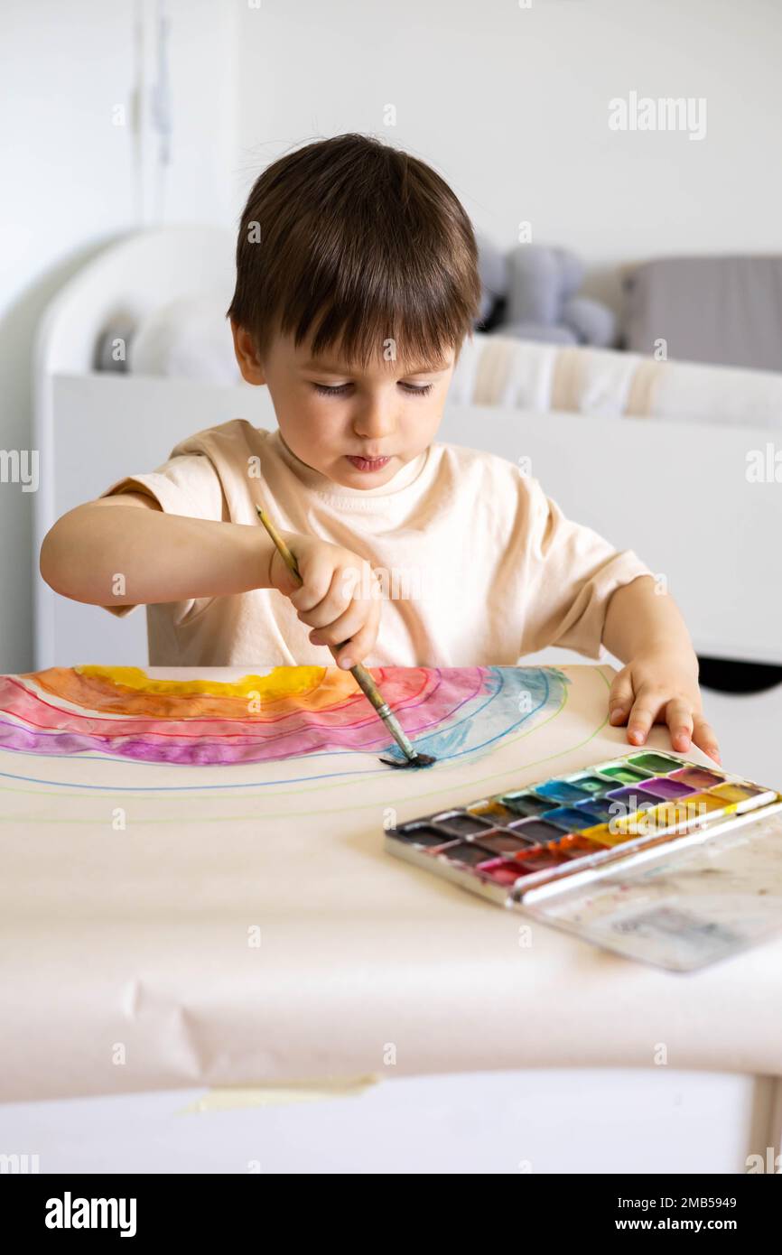 Confident cute male kid art drawing multicolored rainbow arch use ...