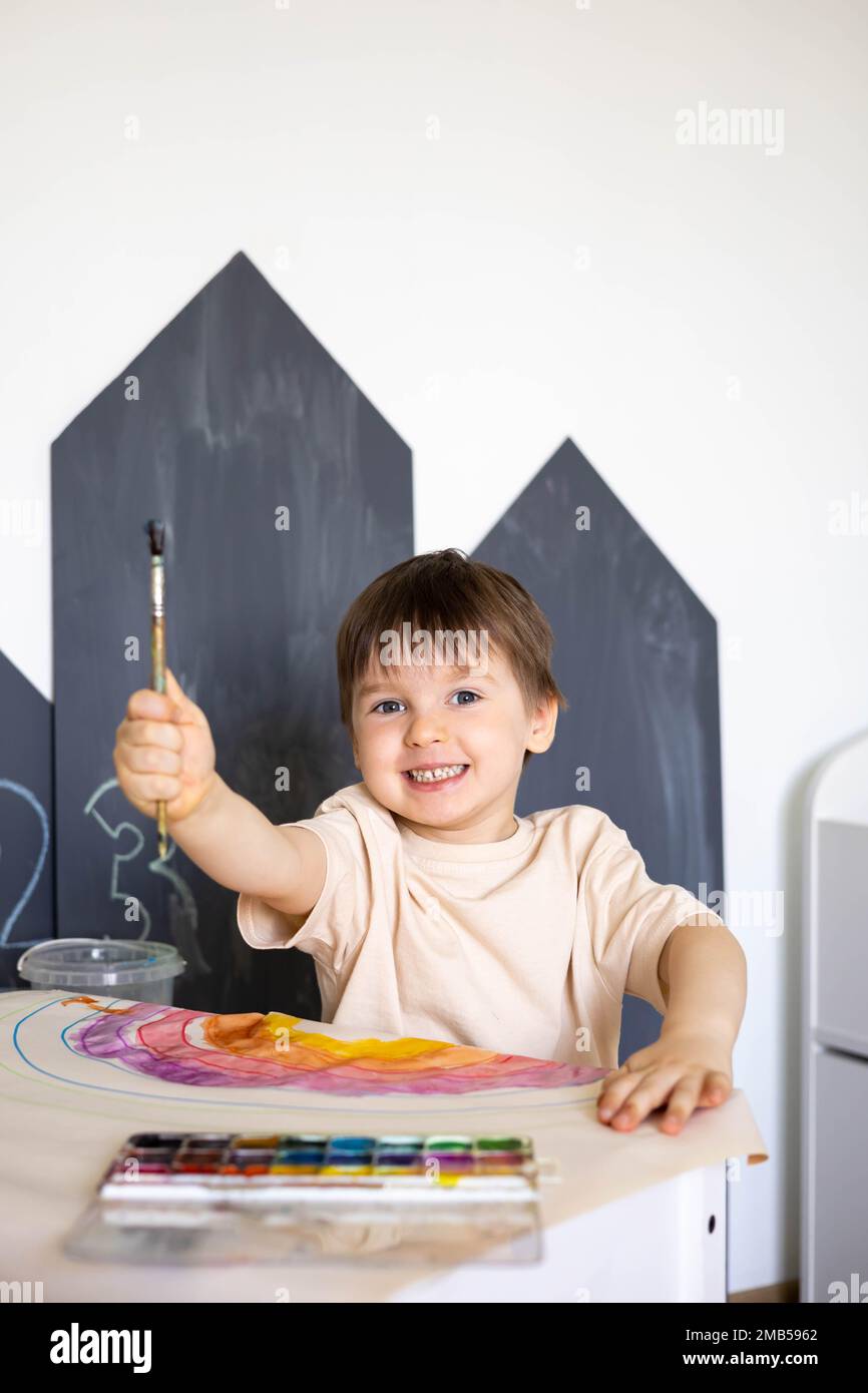 Confident cute male kid art drawing multicolored rainbow arch use ...