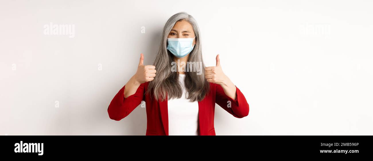 Coronavirus and business concept. Asian female entrepreneur in face ...