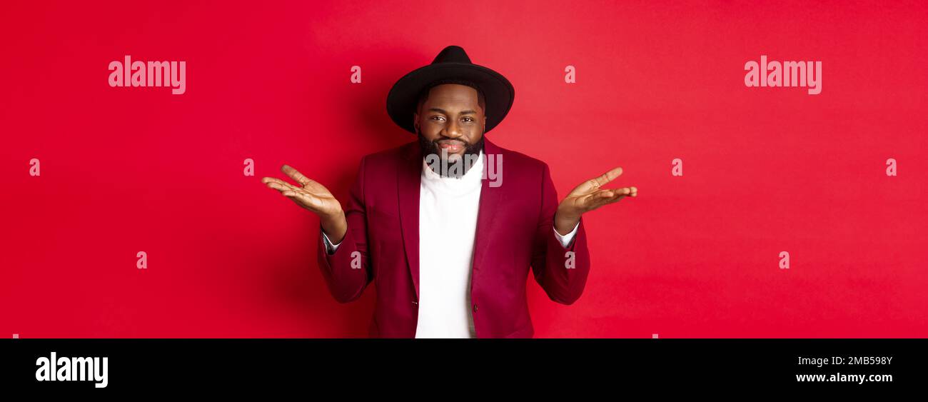 Clueless and unbothered Black man shrugging with indifferent look, dont ...