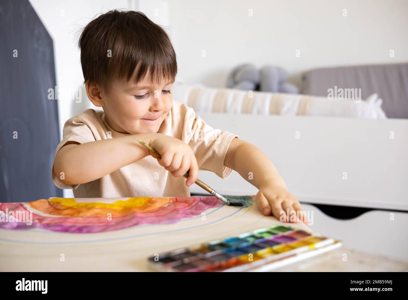 Confident cute male kid art drawing multicolored rainbow arch use ...