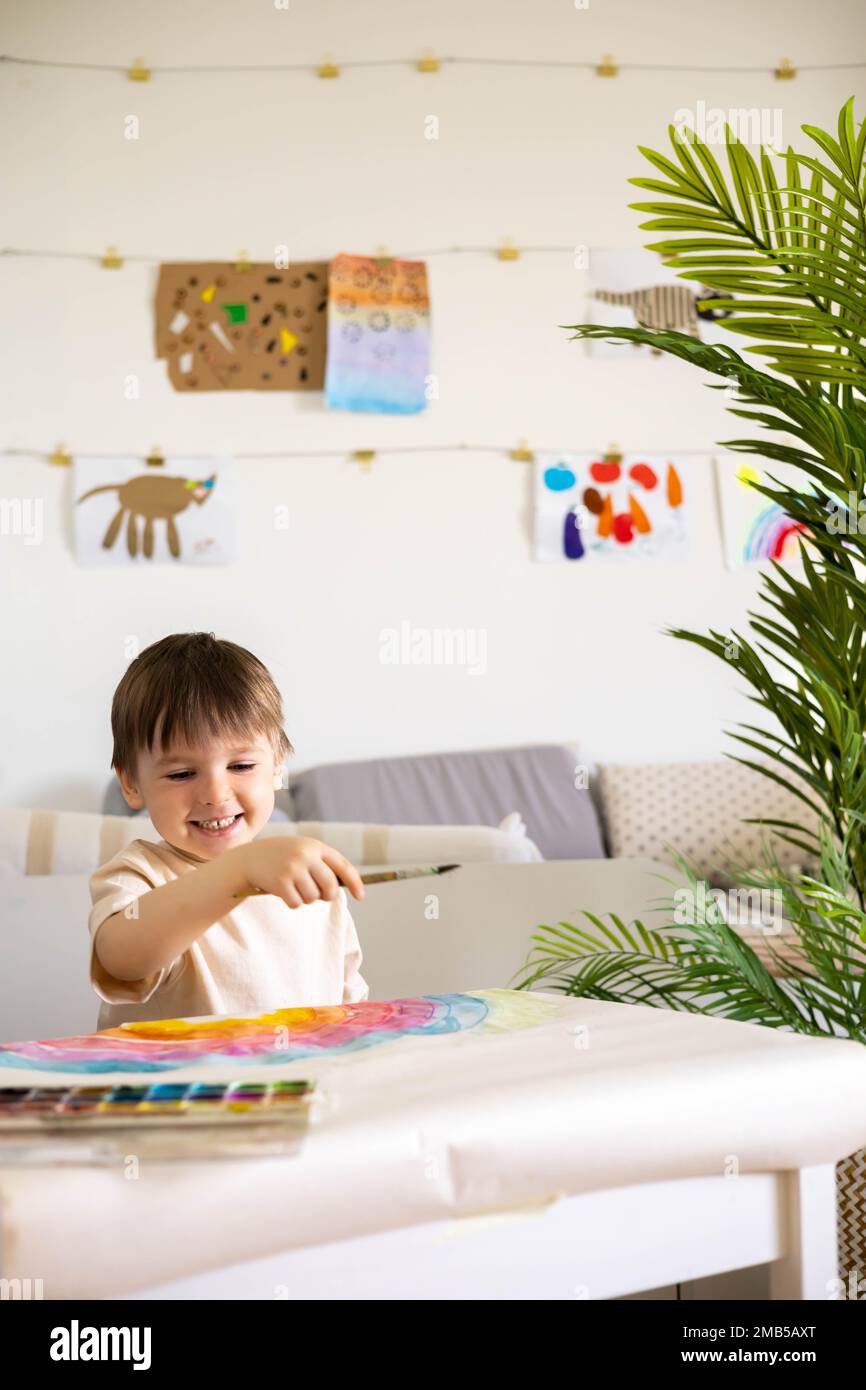 Confident cute male kid art drawing multicolored rainbow arch use ...