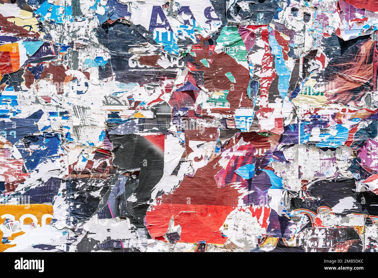 Torn paper collage background on an old poster on a street wall ...