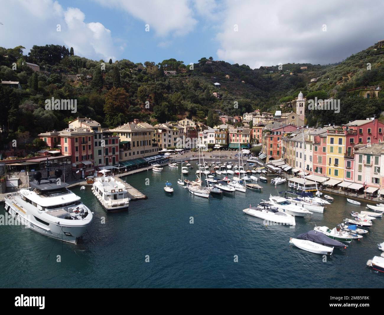 A high angle shot of a port by the city and sea full of white boats ...