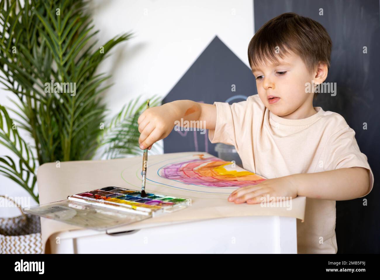 Confident cute male kid art drawing multicolored rainbow arch use ...