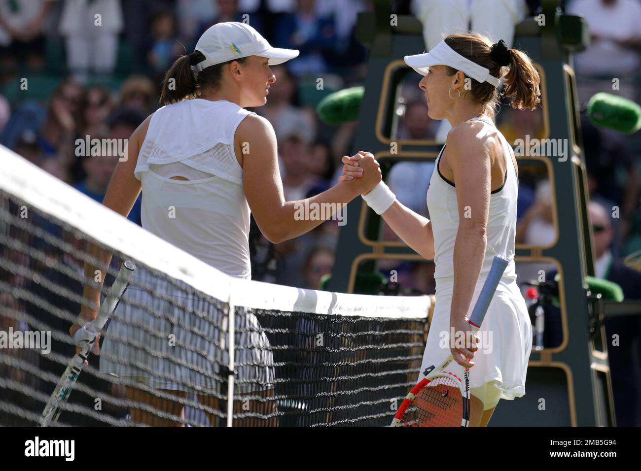 France's Alize Cornet, right, shakes hands with Poland's Iga Swiatek ...