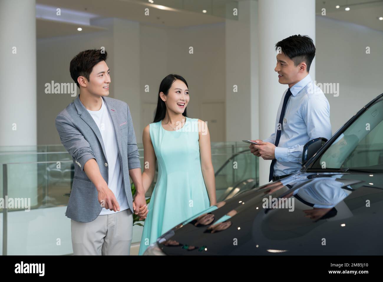 Young couples to buy cars Stock Photo - Alamy