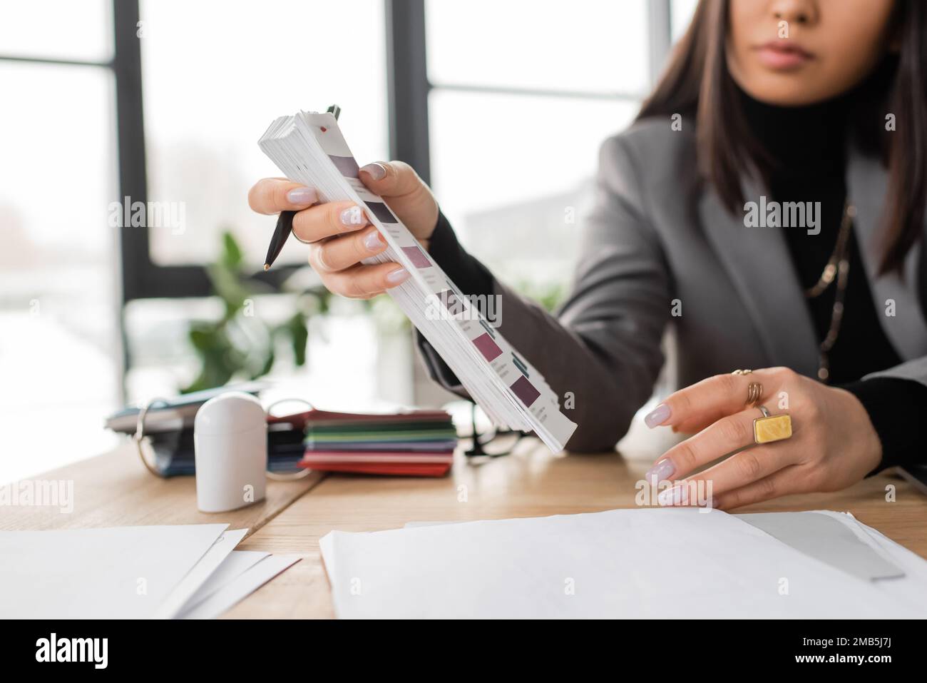Cropped view of blurred designer holding color samples in studio shot ...