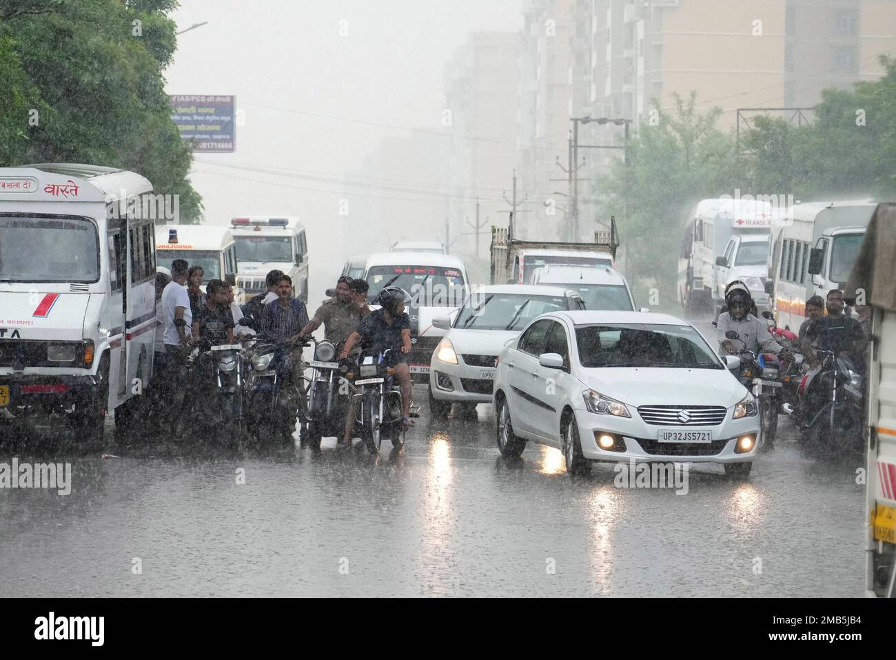 People wait at a turn as it rains in Lucknow, in the northern Indian ...