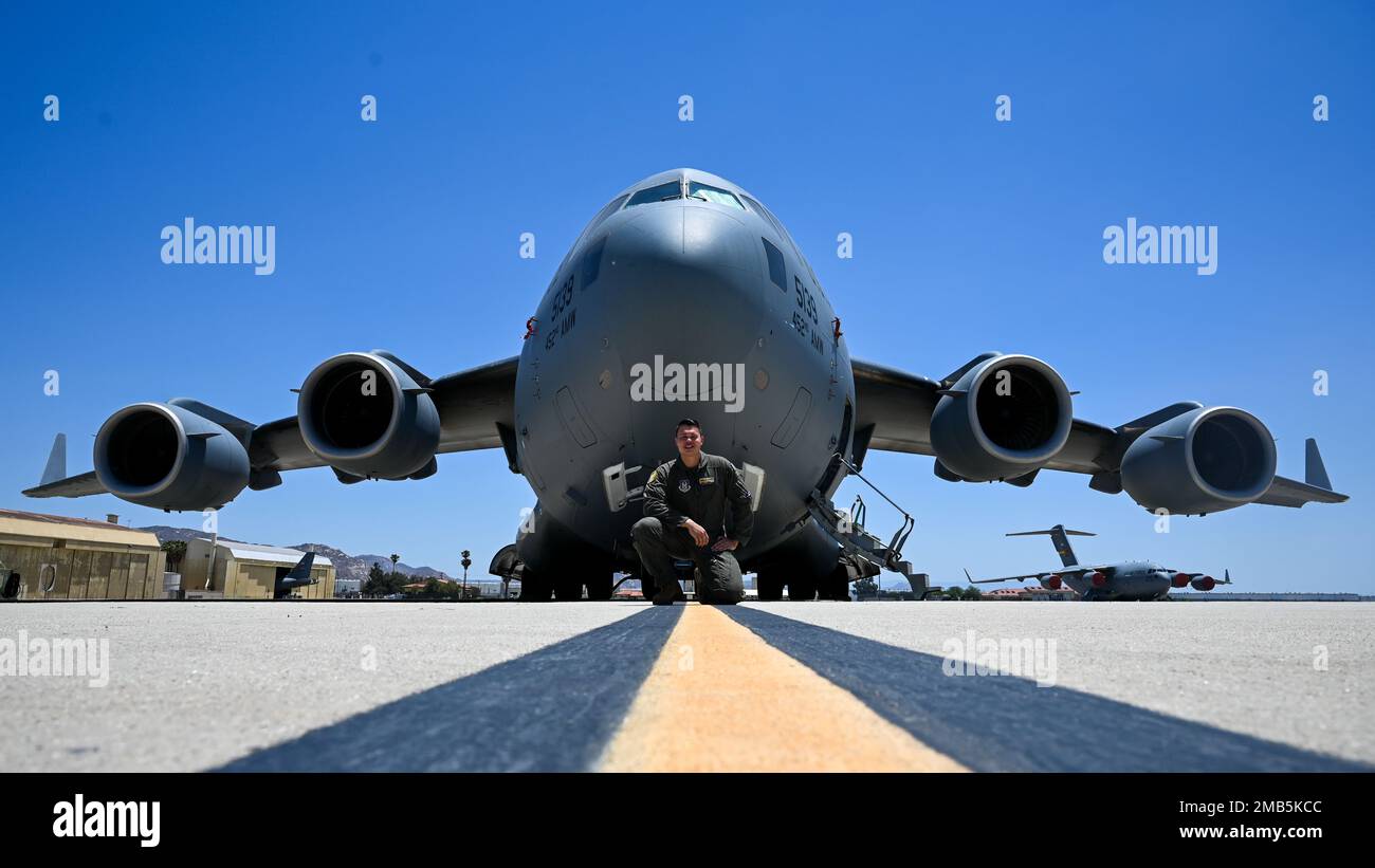 U.S. Air Force SrA. Casey Bernatz, 729th Airlift Squadron crouches for a photo in front of the C ...