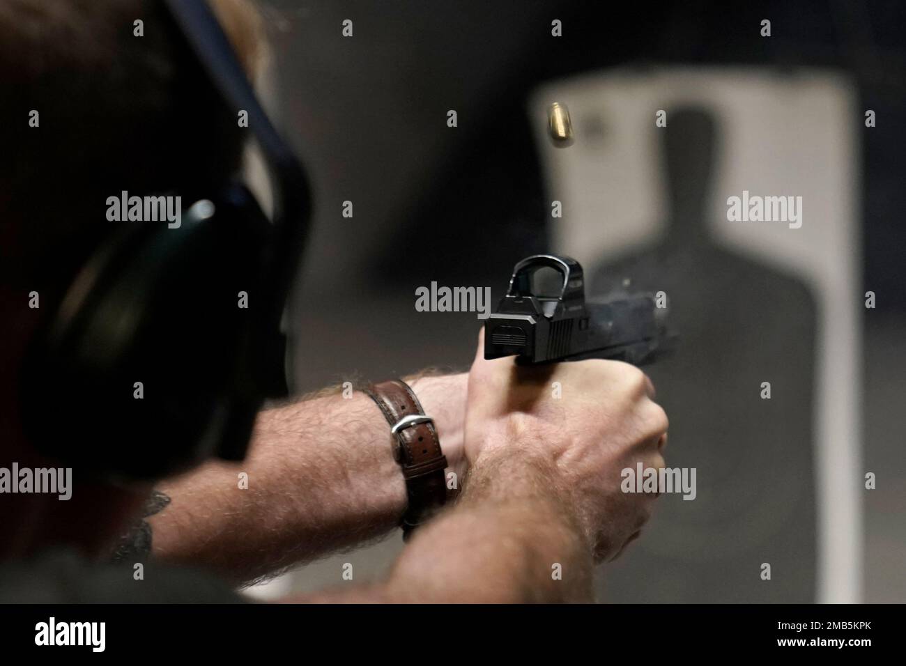 Ettore Russo fires his pistol at an indoor shooting range during a ...