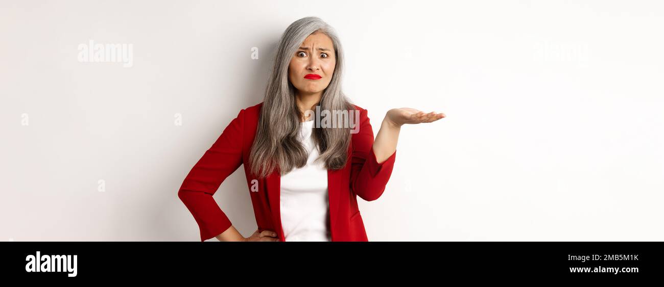 What is this. Confused and skeptical asian female entrepreneur pointing ...
